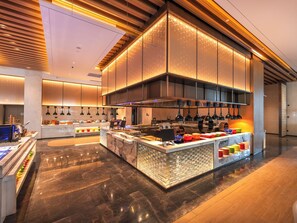 Cozinha moderna com ilha central, iluminação embutida e piso de mármore polido.