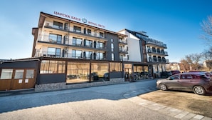 Hotel com vários andares, varandas e céu claro.