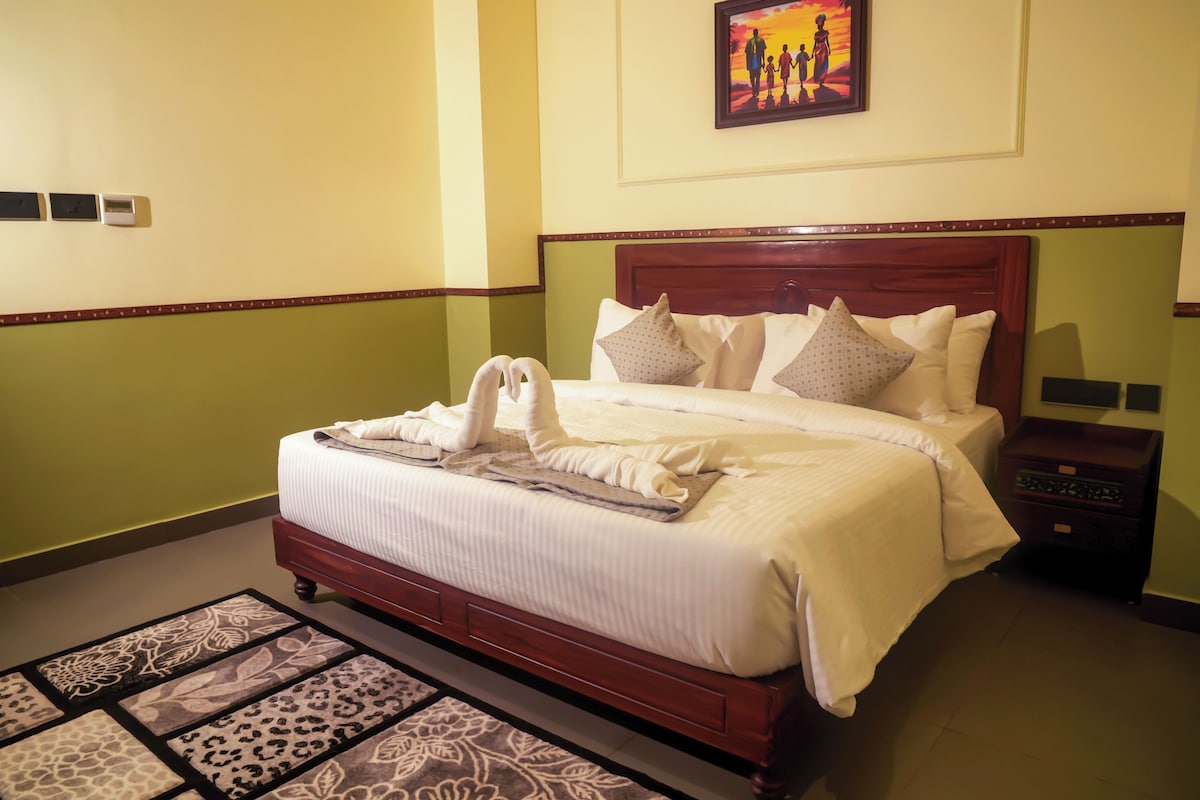 Uma cama bem arrumada com cabeceira, mesa de cabeceira e criado-mudo.