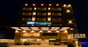 Hotel com fachada moderna, placa chamativa para SureStay by Best Western e entrada bem iluminada.