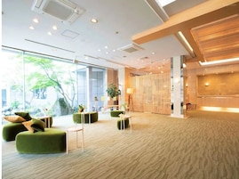 Um lobby moderno com balcão de recepção, área de estar e grandes janelas.