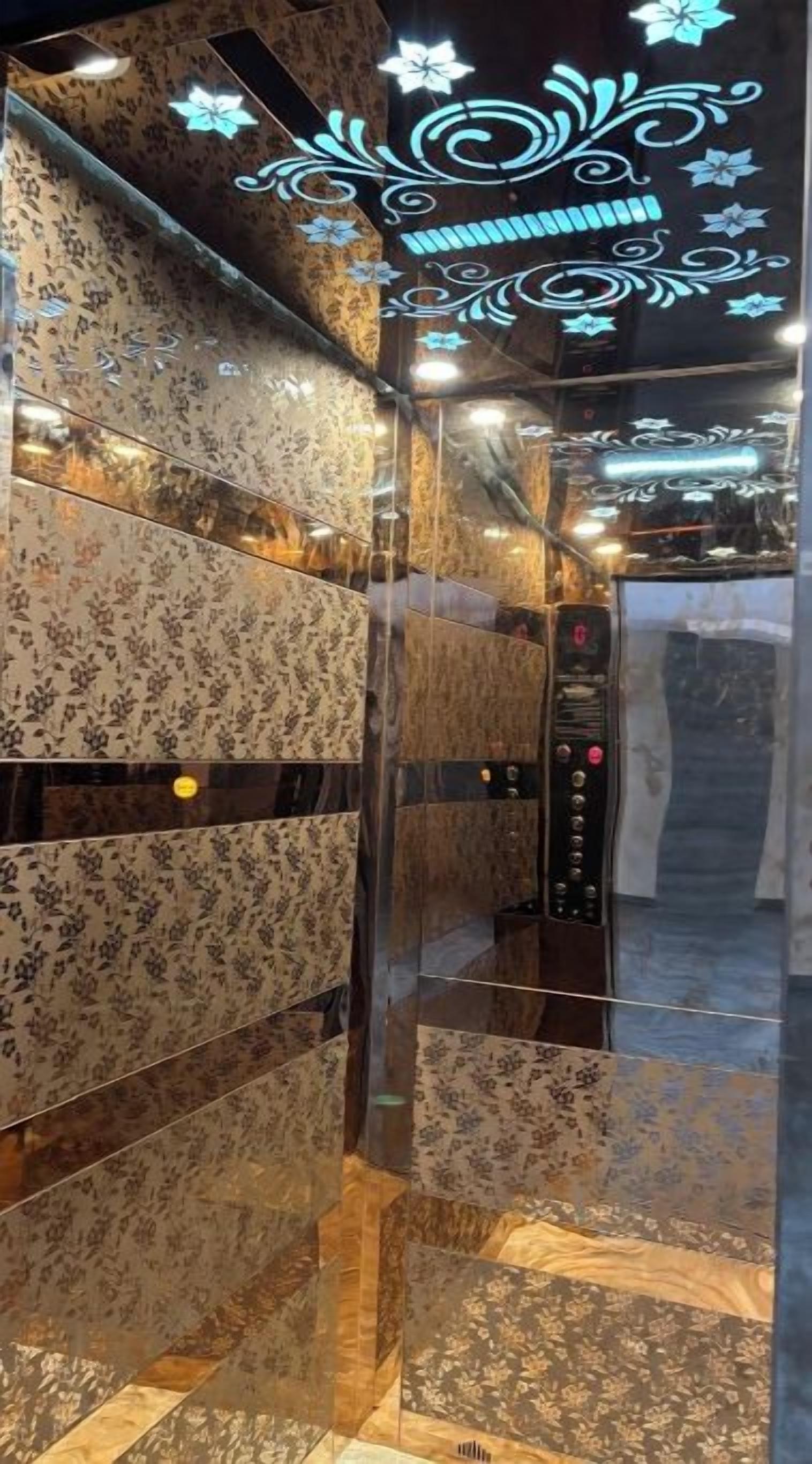 Um elevador com paredes refletoras e um painel de controle.