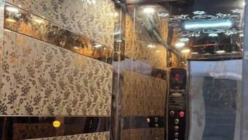 Um elevador com paredes refletoras e um painel de controle.
