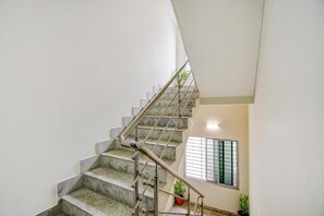 Uma escadaria com grades de metal que leva a um patamar.