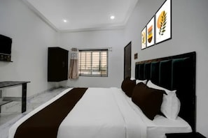 Quarto com cama, janela com persianas, guarda-roupa e quadros na parede.