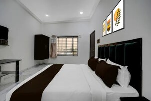 Quarto com cama, janela com persianas, guarda-roupa e obra de arte na parede.