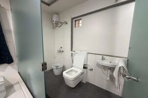 Casa de banho com sanita, bidé e lavatório.