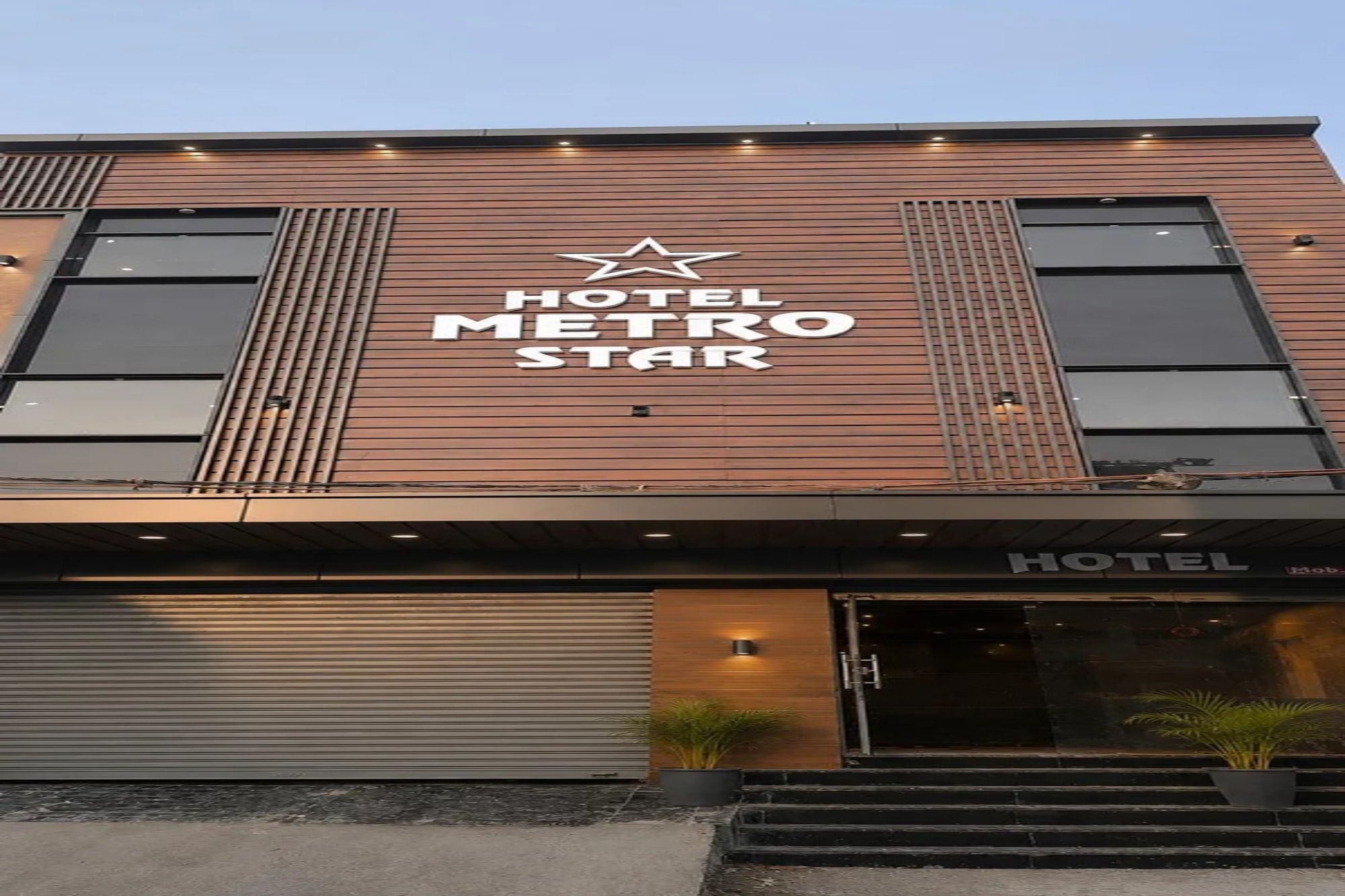 Um edifício moderno com uma placa que diz 'HOTEL METRO STAR'.