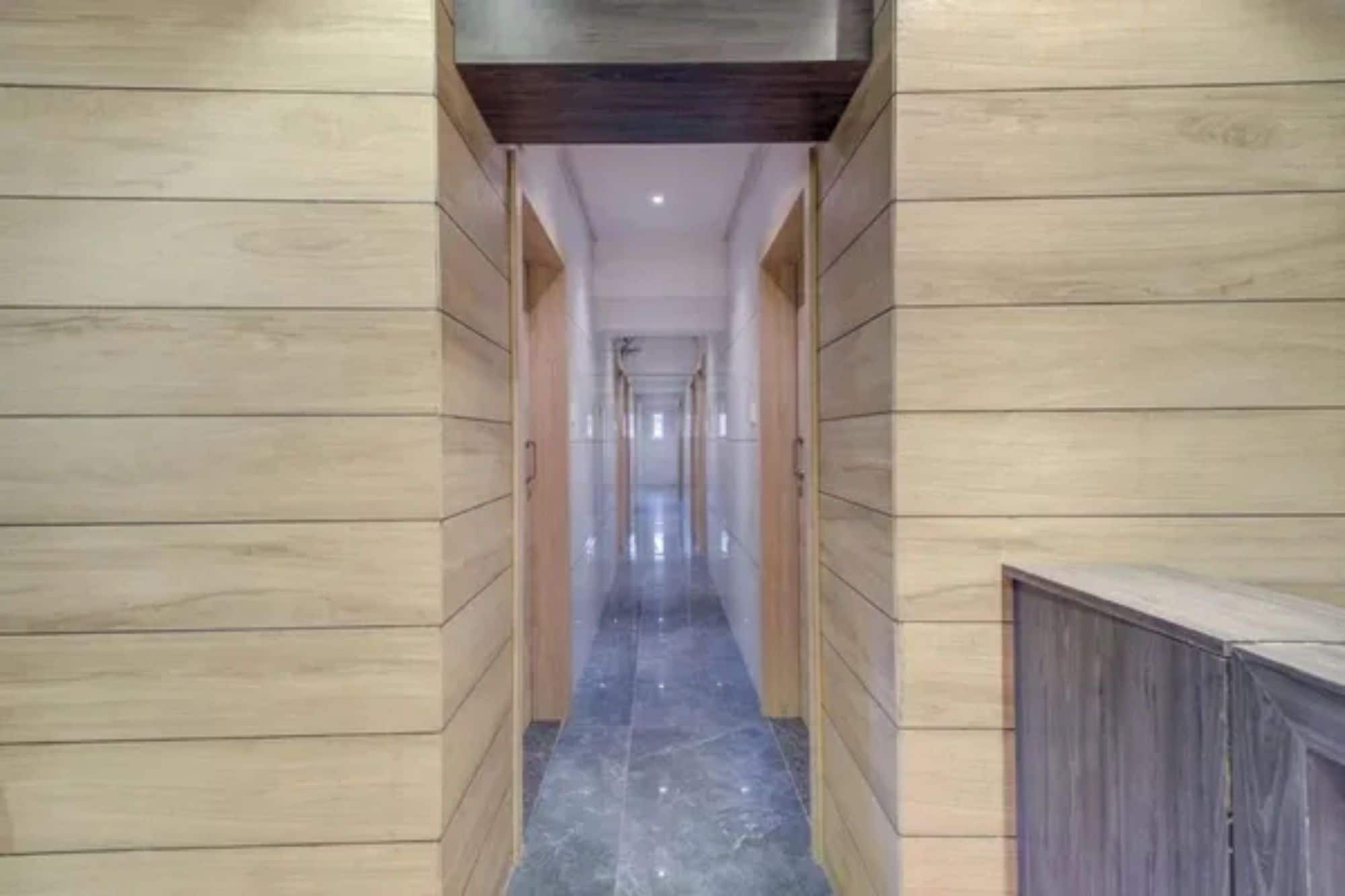 Um corredor com painéis de madeira nas paredes e piso de mármore.