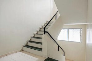 Escada com corrimãos pretos que levam a um andar superior.