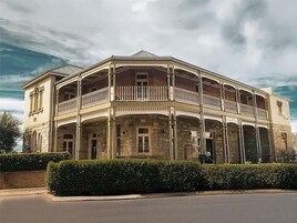 Um edifício histórico com varanda, identificado como 'Argyle Hotel', com fachada simétrica e várias janelas.