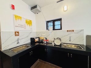 Cozinha moderna com duas pias, bancadas pretas, painel de backsplash de mármore e janela com vista.