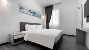 Quarto de hotel com cama, mesa de cabeceira, um quadro, janela com cortinas e televisão na parede.