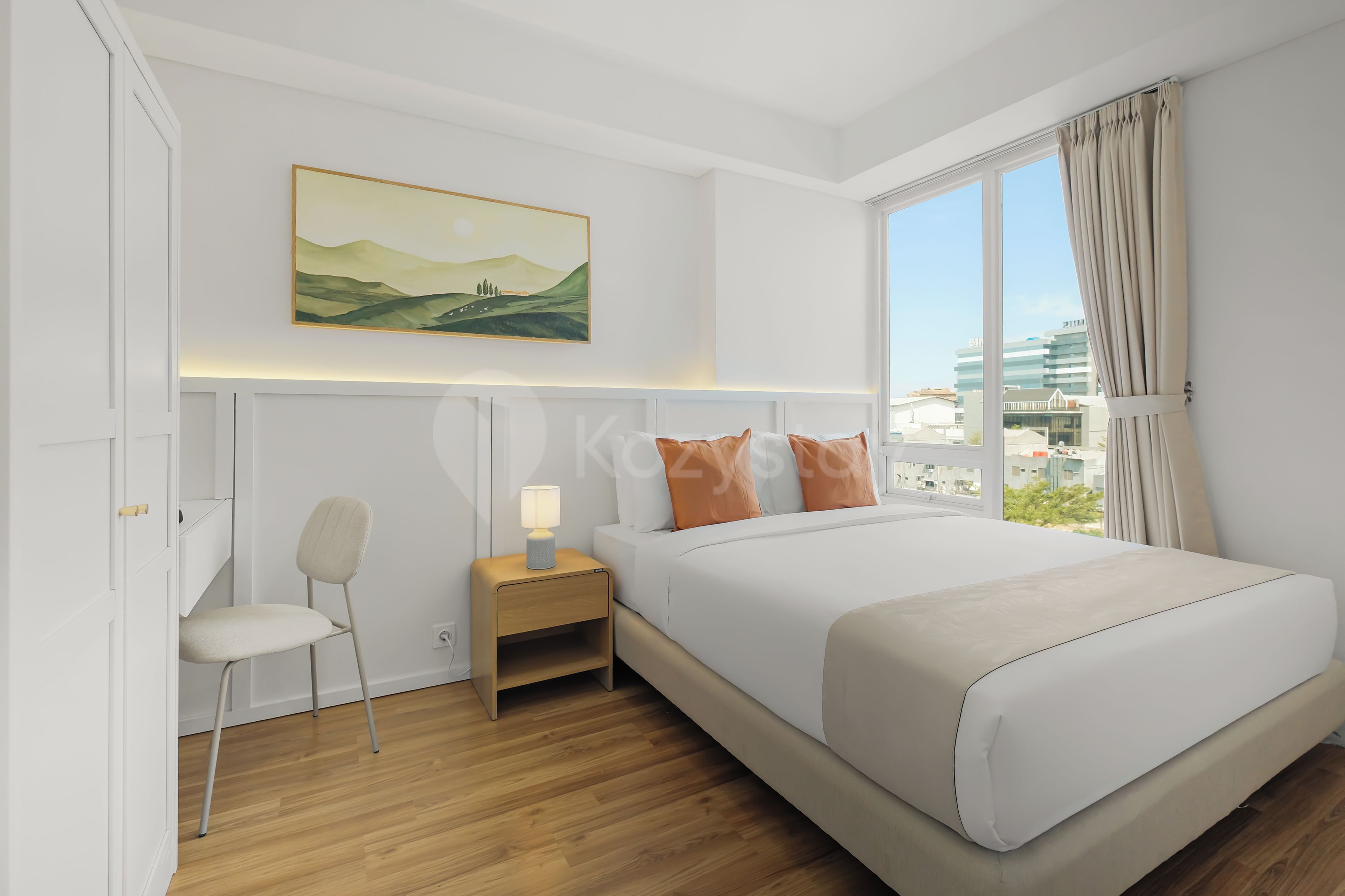 Quarto de hotel com cama, mesa de cabeceira, cadeira, quadro na parede e janela com cortinas.