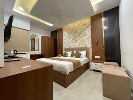 Quarto moderno com cama, mesas de cabeceira, escrivaninha e um espelho grande.