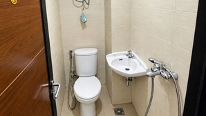 Casa de banho pequena com sanita, bidé e lavatório.