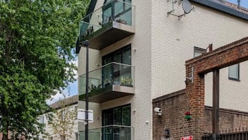 Um edifício moderno com fachada de tijolos, janelas amplas e uma varanda.