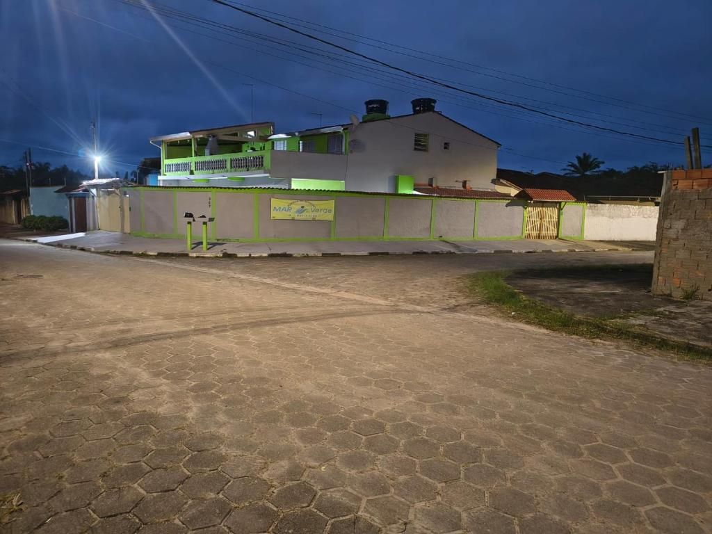Um edifício com telhado plano, uma varanda e uma placa na parede.