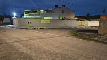 Um edifício com telhado plano, uma varanda e uma placa na parede.