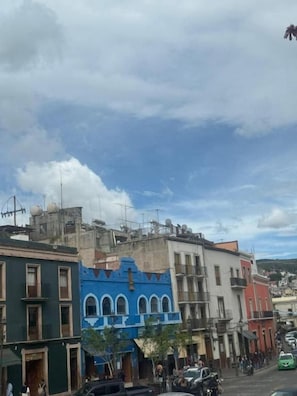 Rua com edifícios de vários andares, alguns com varandas e antenas parabólicas.