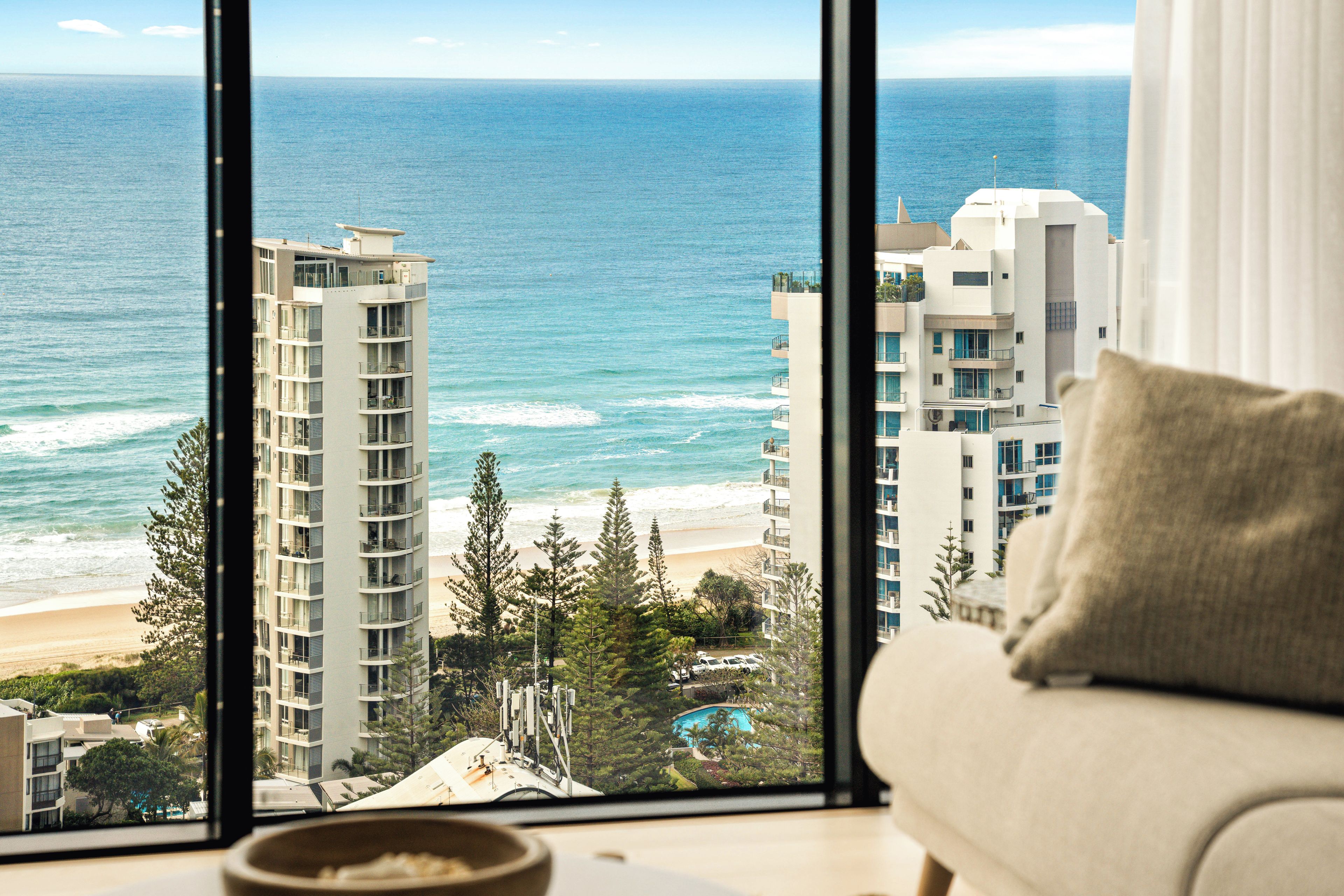 Um edifício alto com vista para o oceano e a praia.