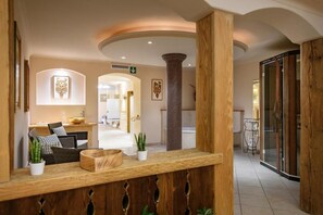 Área de recepção com balcão de madeira, assentos e vista para um corredor com um balcão de atendimento e porta de vidro.