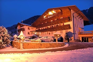 Um hotel com fachada de madeira, várias varandas e paisagem coberta de neve.