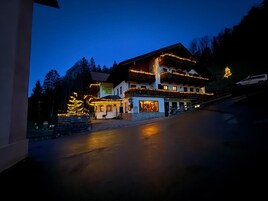 Um hotel com arquitetura alpina tradicional, destacando uma entrada imponente e várias varandas.