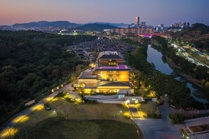 Hotel com design moderno, rodeado por vegetação exuberante e um rio.