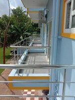 Um edifício com fachada azul, escadas com grades de metal e uma janela com moldura branca.
