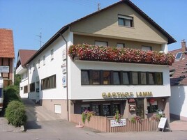 Um edifício de dois andares com uma placa que diz 'GASTHOF LAMM'.