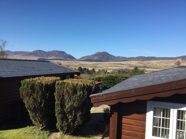 Uma cabana com vista para montanhas, céu claro e uma antena parabólica.