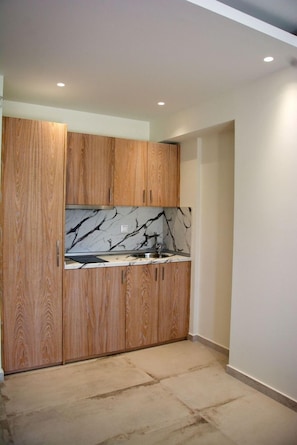 Cozinha com armários de madeira e painel de backsplash de mármore.