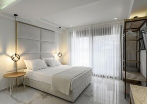 Quarto moderno com uma cama grande, mesas de cabeceira, guarda-roupa e uma janela ampla com cortinas leves.