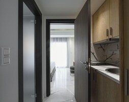 Cozinha moderna com armários de madeira e painel de fundo em mármore.