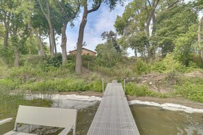 Caminho de madeira que leva a uma casa cercada por árvores e vegetação.
