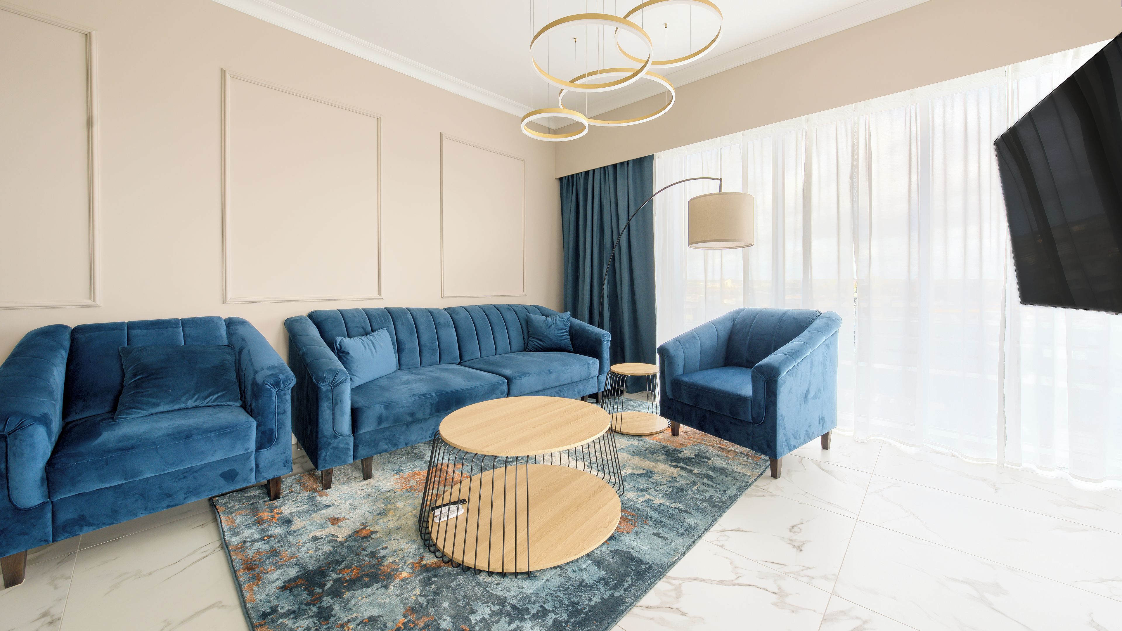 Uma sala de estar moderna com um sofá seccional, duas poltronas e uma mesa de centro.