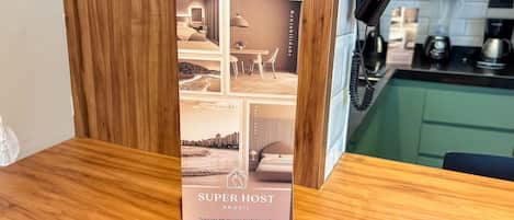 Um folheto intitulado 'SUPER HOST BRASIL' com imagens temporárias de um quarto de hotel, uma vista para a praia e um panorama urbano.