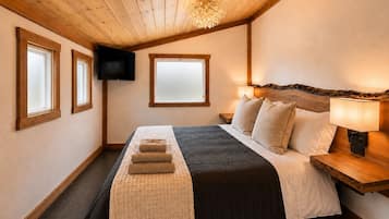 Quarto com uma cama, televisão e janela.