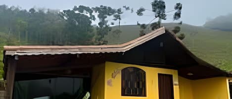 Um edifício amarelo com um deck de madeira e uma rede.