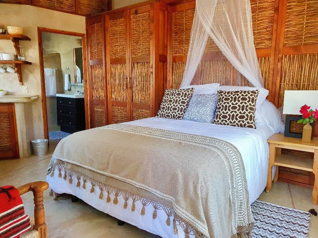 Uma cama com dossel, uma mesa de cabeceira e um criado-mudo.
