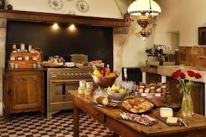Uma cozinha com chão quadriculado, armário de madeira, fogão, cafeteira e diversos alimentos sobre o balcão.
