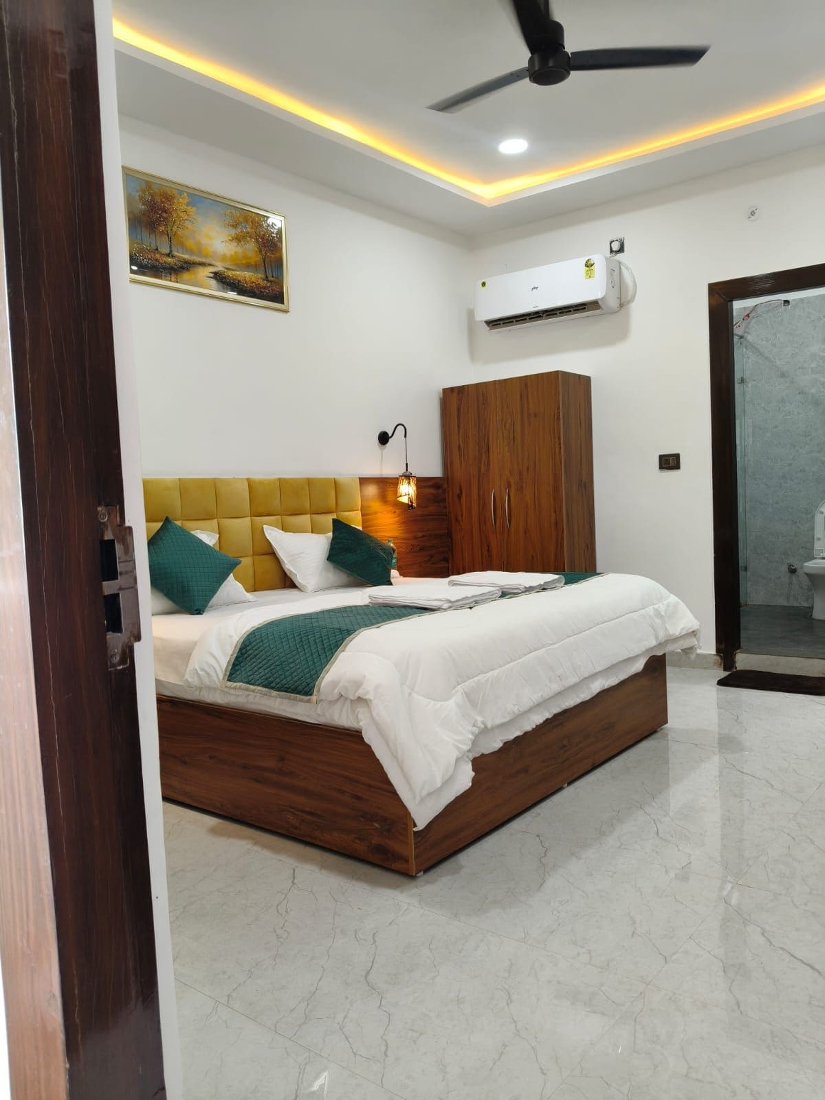 Quarto com cama, guarda-roupa, ar condicionado e ventoinha no teto.