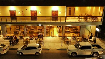 Edifício com vários andares, áreas de estar ao ar livre e estacionamento.