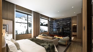 Quarto moderno com cama grande, área de estar, lareira e TV fixada em uma parede de pedra.