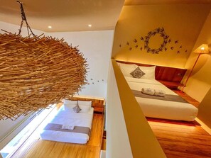 Quarto moderno com lustre de bambu suspenso, cama com roupa de cama branca, cabeceira de madeira e decoração de parede com pássaros.