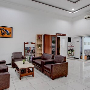 Um interior moderno com sofás de couro, mesa de centro de madeira e estante de livros.