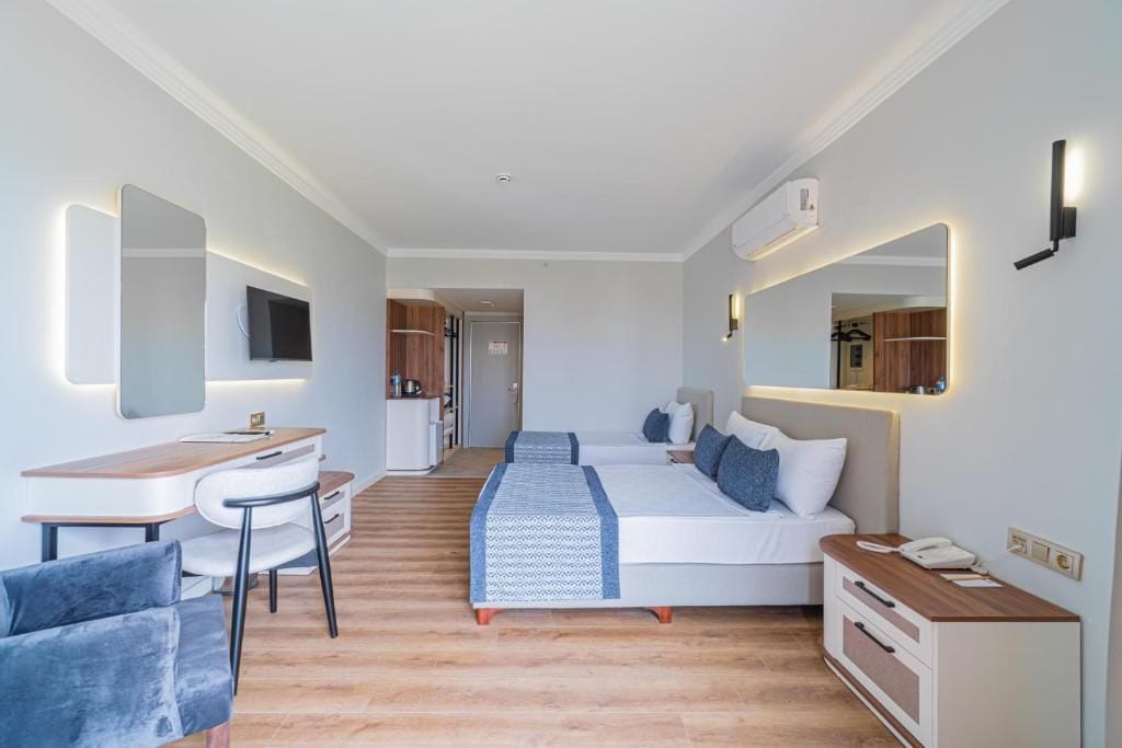 Quarto de hotel moderno com cama, escrivaninha, cadeira e espelho.
