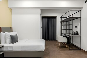 Quarto de hotel moderno com cama, escrivaninha e prateleiras embutidas.