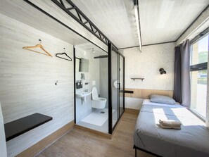 Quarto Individual Comfort, 1 cama individual, casa de banho anexa, no rés do chão | Casa de banho | Um polibã, toalhas fornecidas, sabão, champô 